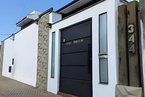 Um edif ício moderno com uma porta preta, um padrão geométrico na parede e o número '344' à direita.