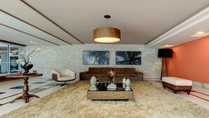Uma sala de estar moderna com uma mesa de centro, um sof á, uma poltrona e um tapete.