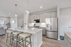 Uma cozinha moderna com ilha central, eletrodomésticos de aço inoxidável e design minimalista.