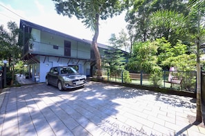 Um edifício de dois andares com um carro estacionado na entrada.