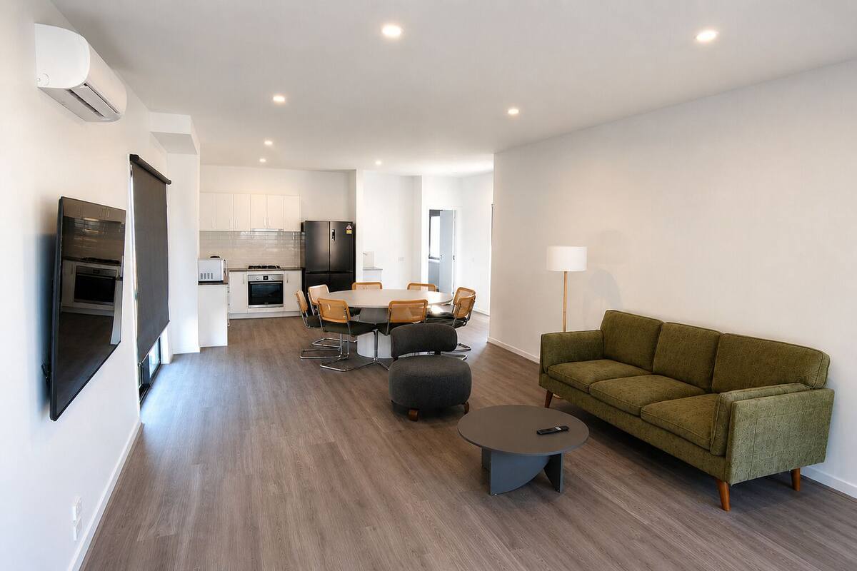 Um apartamento moderno com sala de jantar, cozinha e sala de estar.