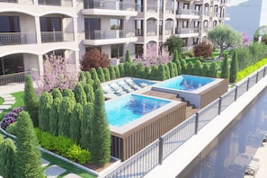 Um hotel com vários andares, piscinas ao ar livre, um jardim bem cuidado e vista para o rio.