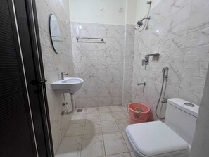 Um banheiro pequeno com pia, vaso sanitário e chuveiro.