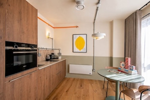 Uma cozinha moderna com forno embutido, máquina de café e luminária fixada na parede.