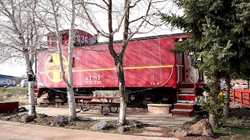 Um vagão de trem vermelho com a marca 'Santa Fe' e o código 'ATSP 999336' visíveis.