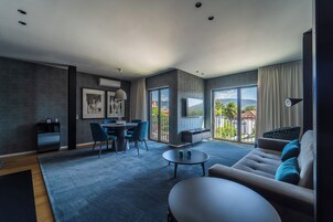 Uma sala de estar moderna com sofá, mesa de centro e área de jantar.