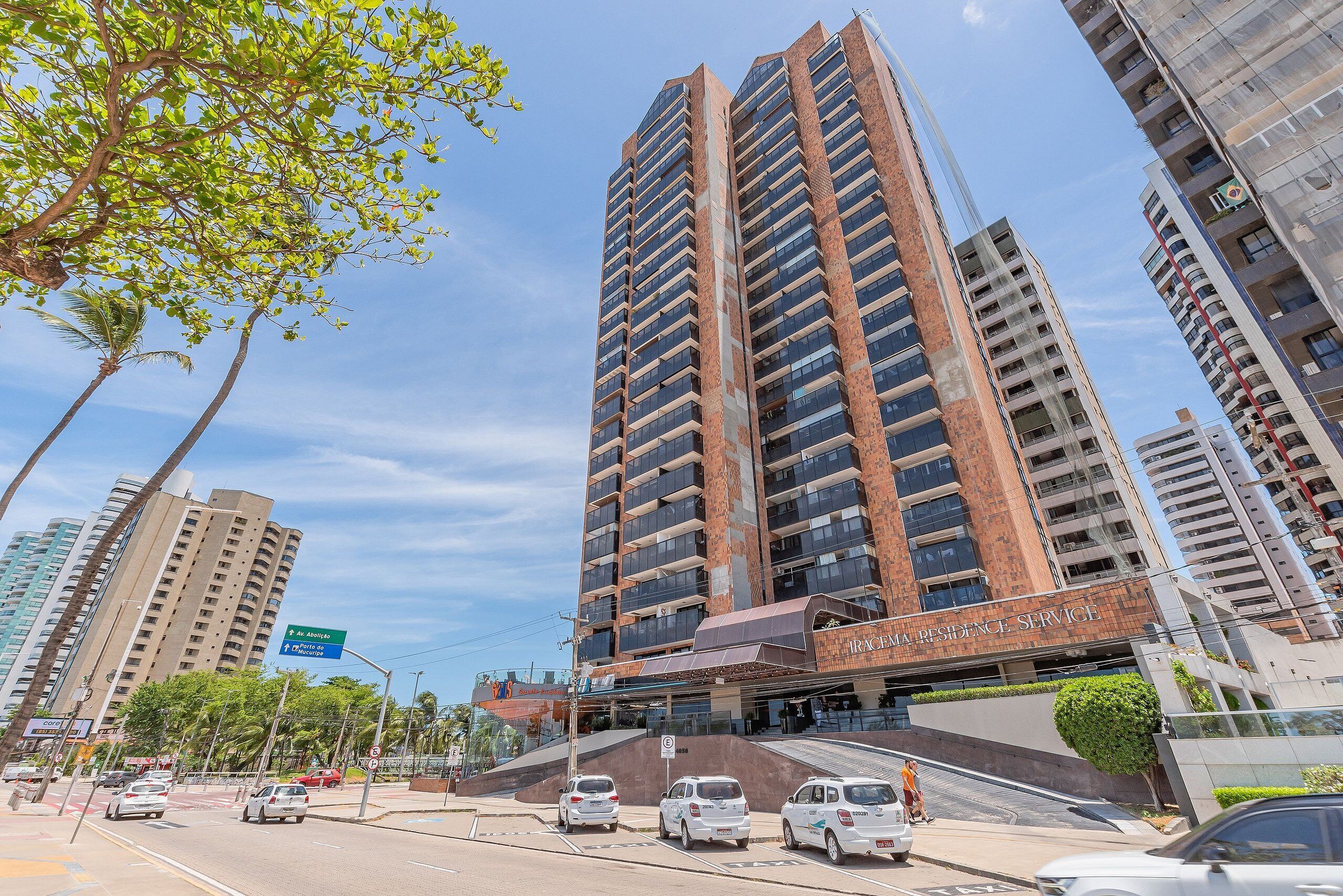 Um edifício alto com uma entrada destacada identificada como "IACENIA RESIDENCE SERVICE".