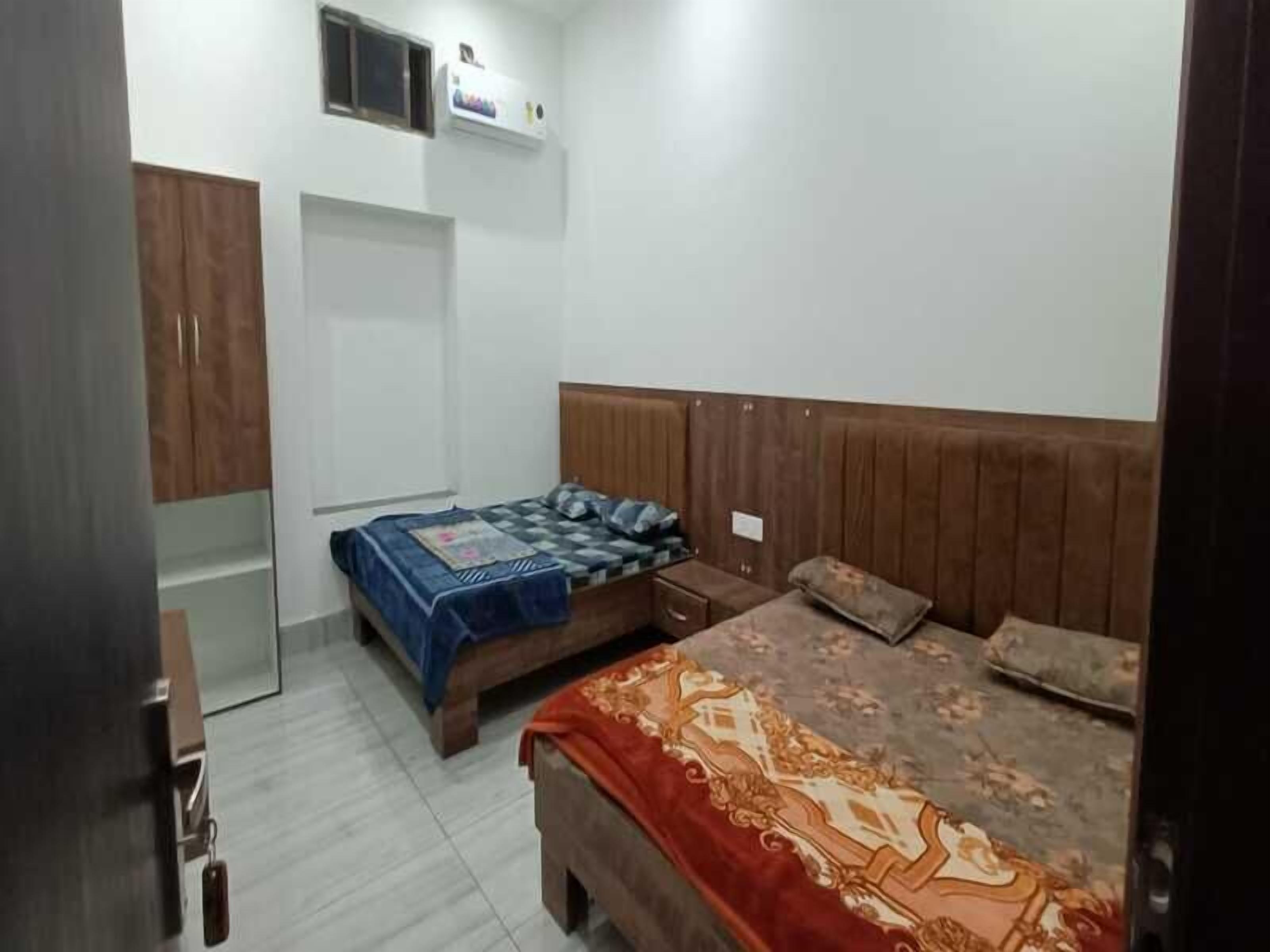 Quarto com uma cama, um guarda-roupa e uma mesinha.