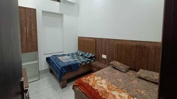 Quarto com uma cama, um guarda-roupa e uma mesinha.