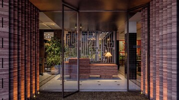 Um interior moderno com uma área de estar central, um painel de vidro e vista para o exterior.