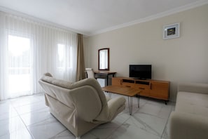Suíte conforto, 1 quarto, sacada, vista para o mar | Área de estar | Smart TV 55 cm com canais via satélite