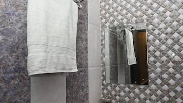 Chuveiro, toalhas de banho, sabonete, shampoo