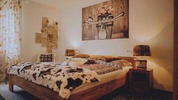Quarto com cama de madeira, um quadro na parede e mesa de cabeceira com abajur.