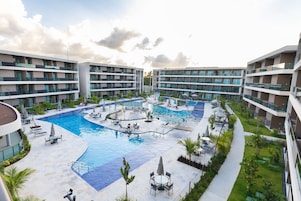 Resort com piscina central, várias varandas e áreas de estar ao ar livre.