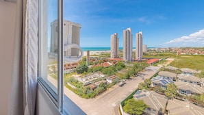Um edifício alto com vários andares, grandes janelas e vista para a área costeira.