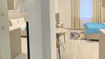 Quarto de hotel moderno com cama, escrivaninha e área de estar.