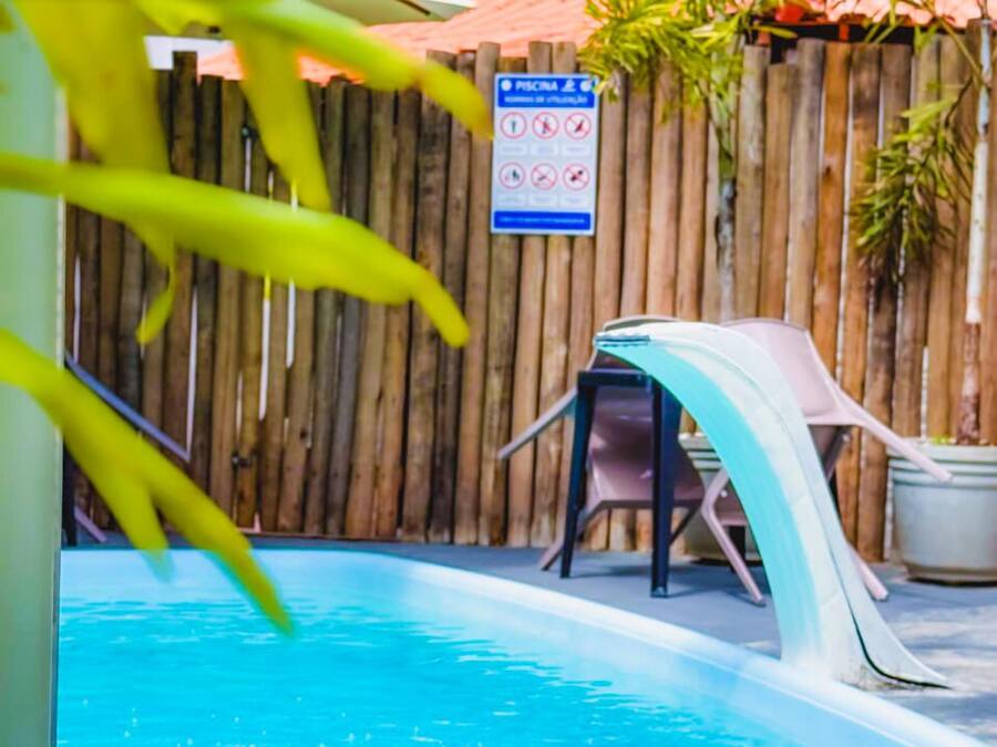 Piscina com cerca de madeira, uma cadeira e uma placa com símbolos.