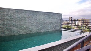 Piscina no terraço com vista desobstruída da paisagem urbana ao fundo.