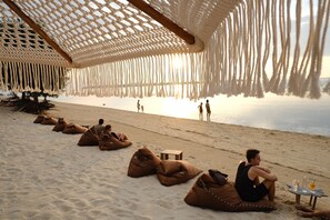 Na praia, barracas de praia de cortesia, espreguiçadeiras, guarda-sóis 