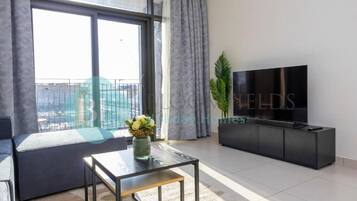 Uma sala de estar moderna com uma janela grande, um sofá, uma mesa de centro, uma televisão e um armário.
