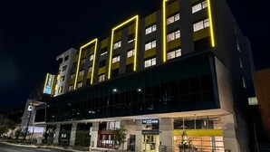 Um hotel moderno com vários andares, grandes janelas e uma placa chamativa para 'The 233 Suites'.