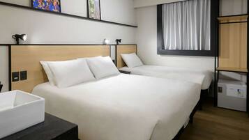 Quarto de hotel com duas camas, mesa de cabeceira, armário pequeno e janela com cortinas.