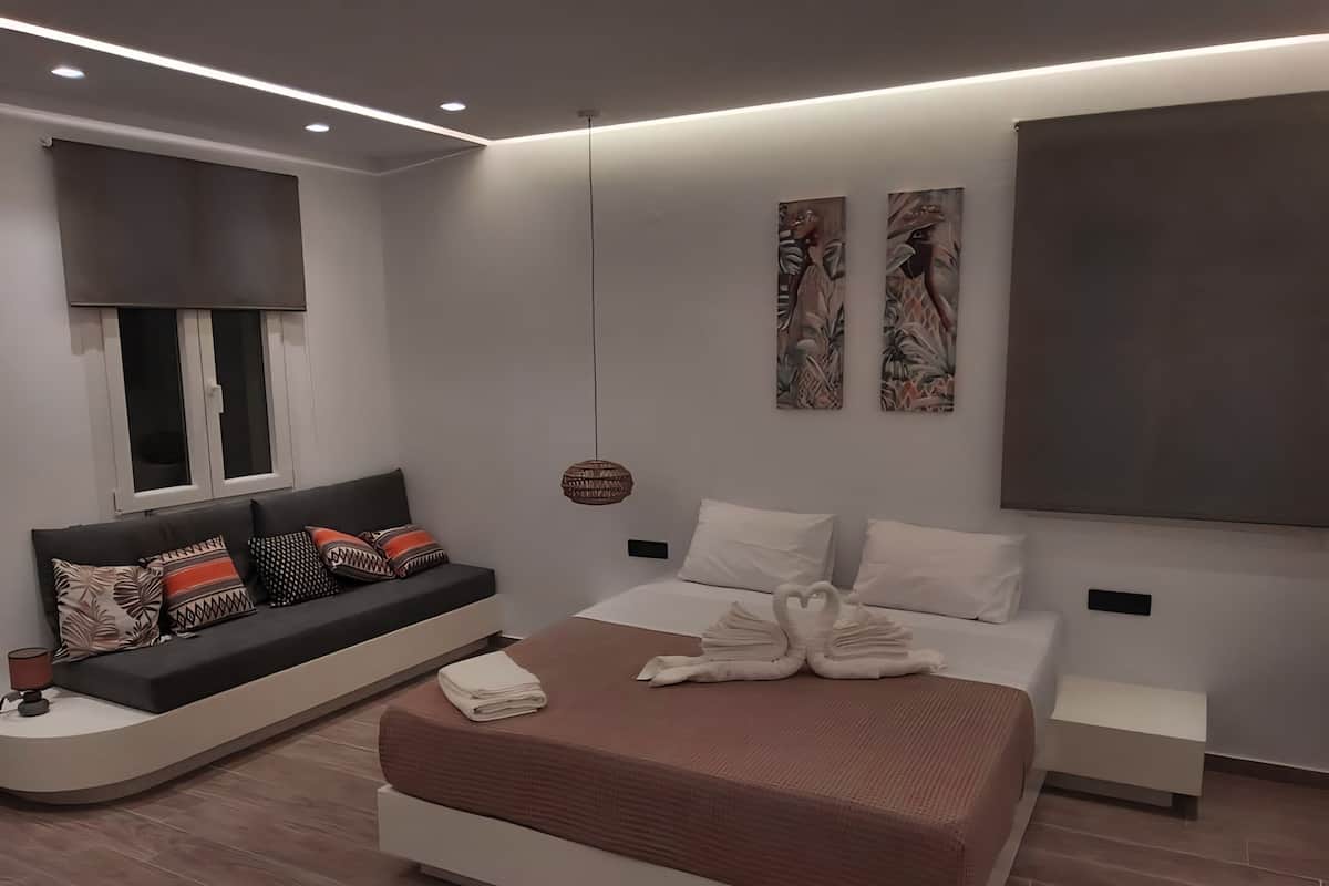 Quarto moderno com uma cama, um sofá e obras de arte nas paredes.