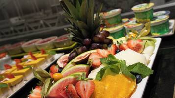 Um buffet com diversas frutas e sobremesas.