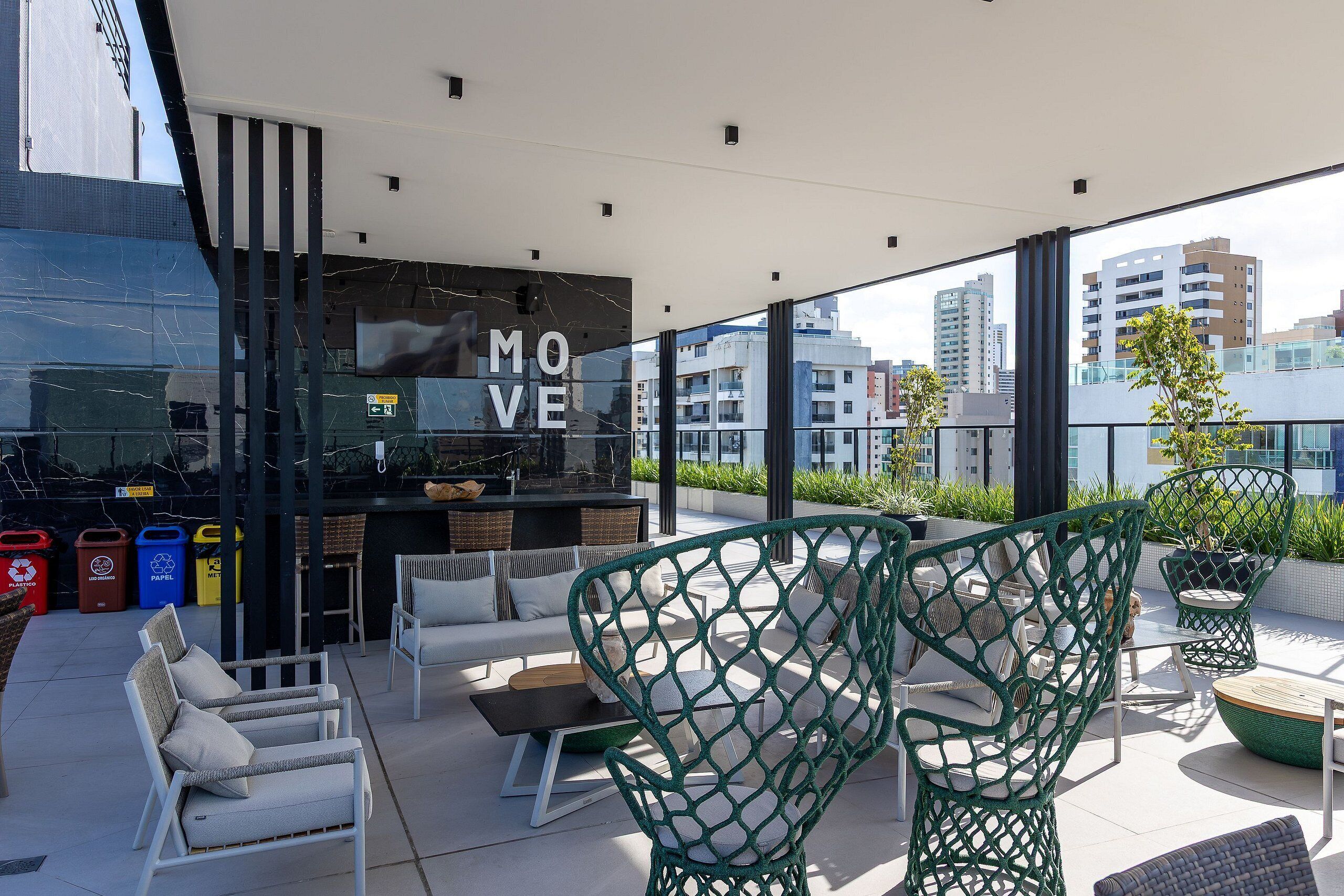Um terraço com área de estar ao ar livre, bar e vista para a cidade.