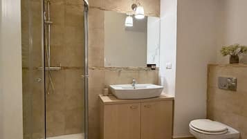 Apartamento Deluxe, 2 quartos | Casa de banho | Um polibã, um secador de cabelo, toalhas fornecidas, sabão