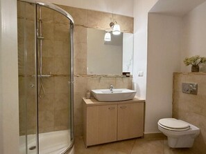 Apartamento Deluxe, 2 quartos | Casa de banho | Um polibã, um secador de cabelo, toalhas fornecidas, sabão 