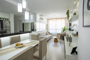 Uma cozinha moderna com área de jantar, um sofá e uma mesa de centro.