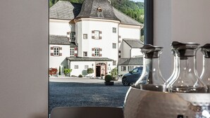 Vista pela janela de um edifício com cúpula, fachada branca e montanhas ao fundo.