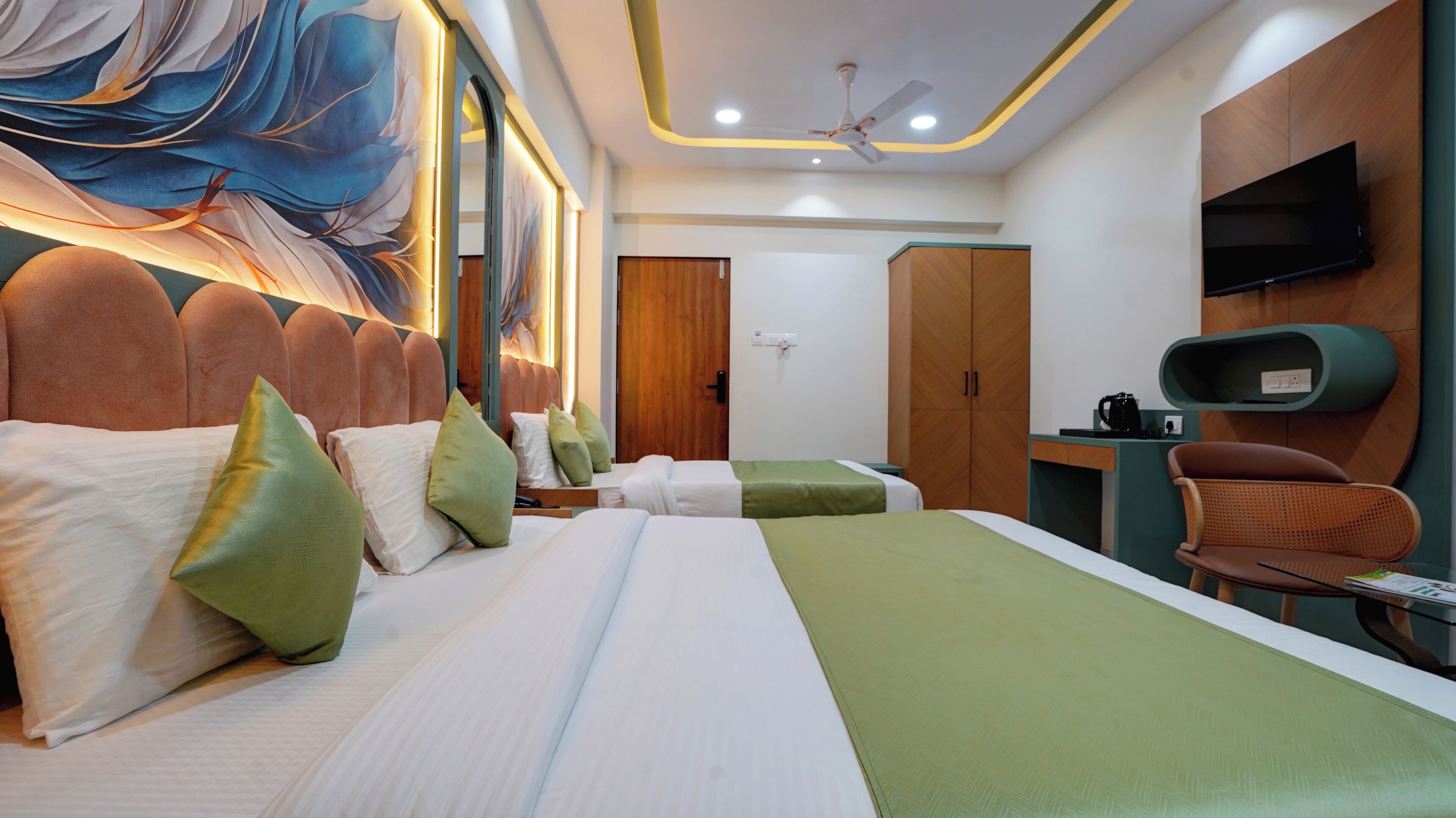 Quarto de hotel com uma cama grande, uma mesa, uma cadeira, uma televisão e um guarda-roupa.