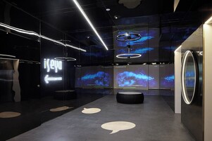 Um interior moderno com parede de vidro, letreiro de neon e área de estar circular.