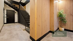 Um interior moderno com parede de madeira, escada e planta em vaso.