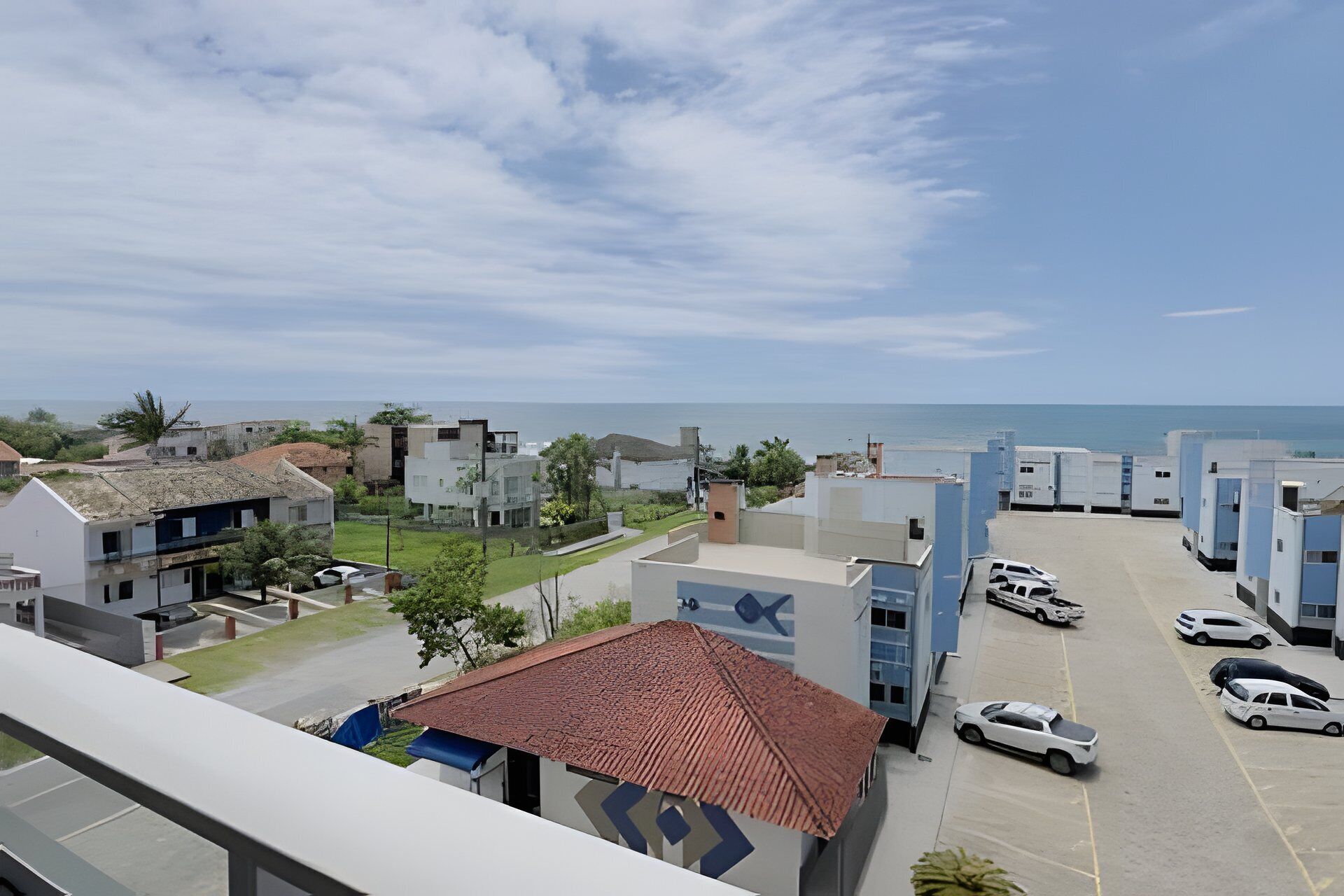 Um hotel à beira-mar com arquitetura moderna, área de estacionamento e vista para o mar.