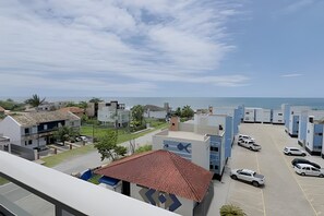 Um hotel à beira-mar com arquitetura moderna, área de estacionamento e vista para o mar.