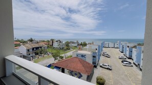 Zona residencial com vista para o mar, com edifícios modernos, um estacionamento e varandas.
