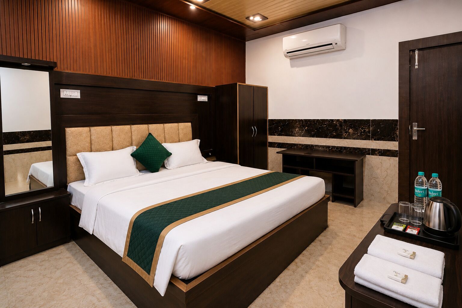 Quarto de hotel com uma cama, uma mesa de trabalho com cafeteira e um minibar.