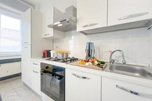 Um frigorífico, um micro-ondas, um forno, uma placa de cozinha 