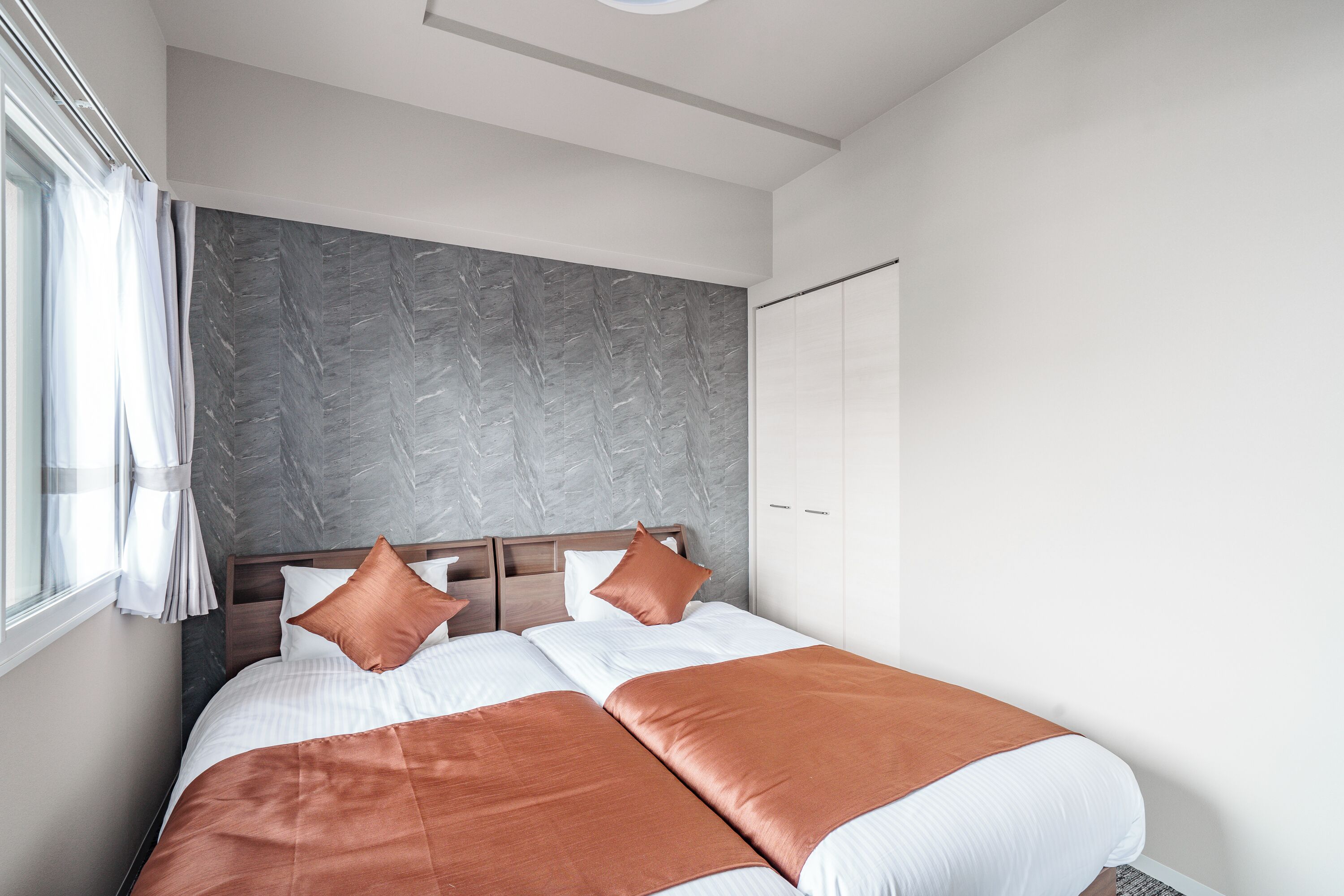 Uma cama de casal com duas almofadas e um cobertor marrom.