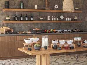 Buffet de café da manhã com diversos alimentos e bebidas.