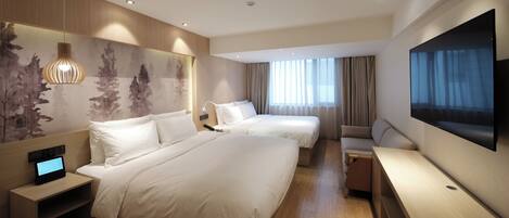 Quarto de hotel com duas camas, televisão, escrivaninha e uma janela grande com cortinas.