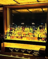 Um bar com uma variedade de garrafas de bebidas e copos.