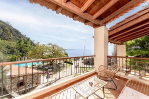 Varanda com vista para uma piscina e montanhas.