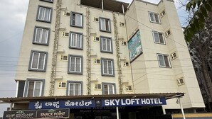 Um hotel com vários andares, com uma placa indicando 'Sky Loft Hotel' e 'Snack Point' abaixo.
