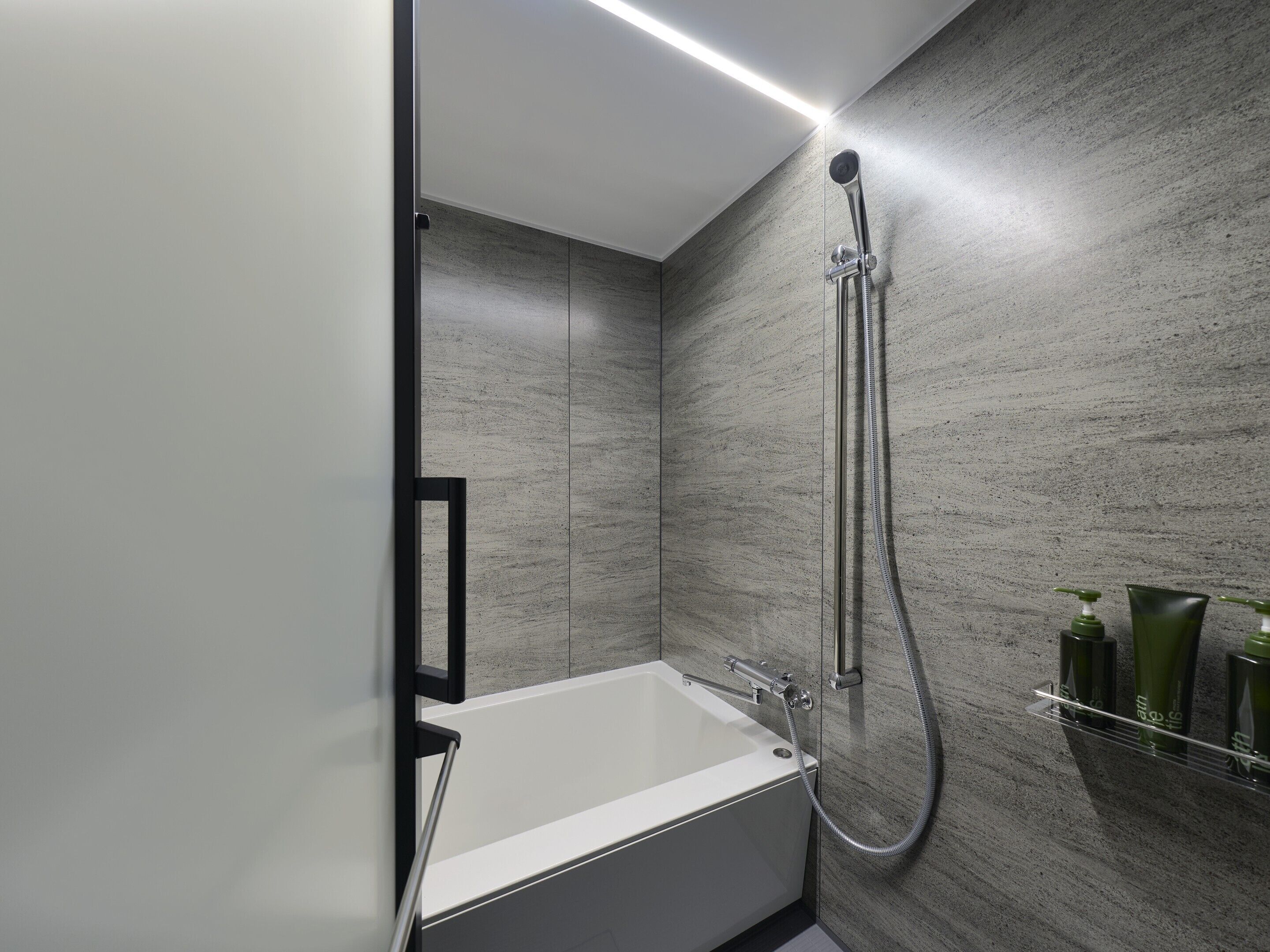 Uma casa de banho moderna com banheira, chuveiro e um espaço para artigos de higiene pessoal.