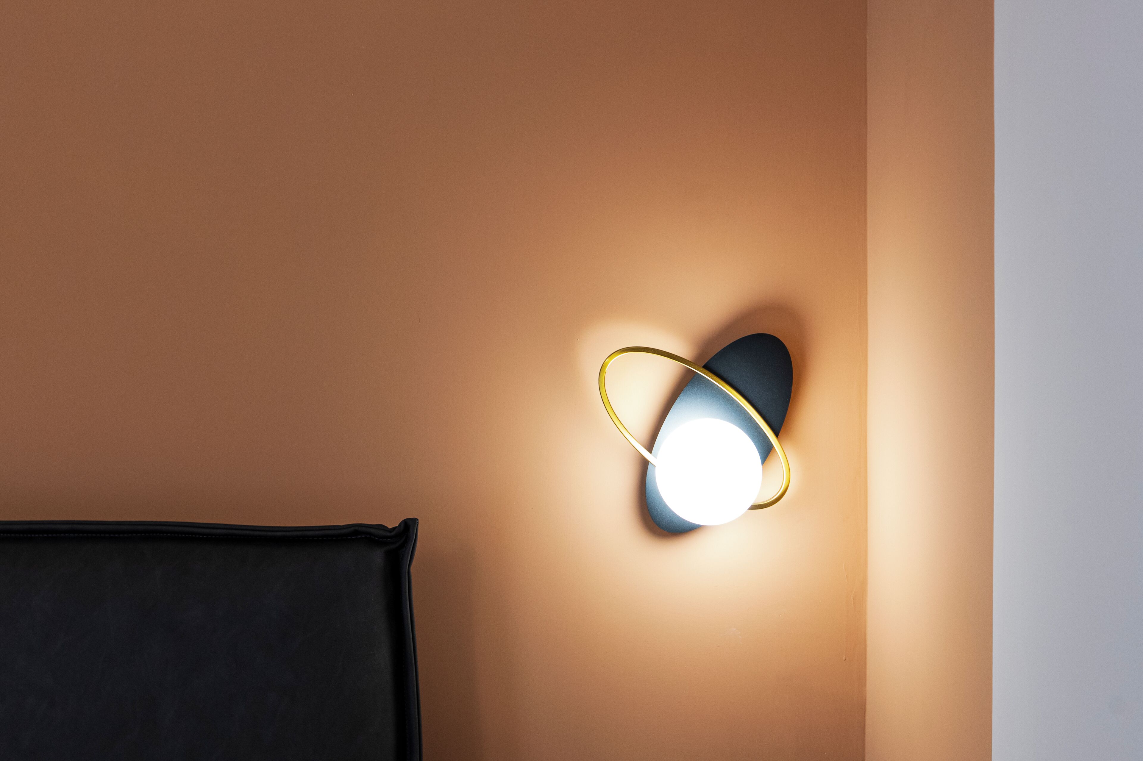 Arranjo de luz fixado na parede, com design circular e lâmpada iluminada.