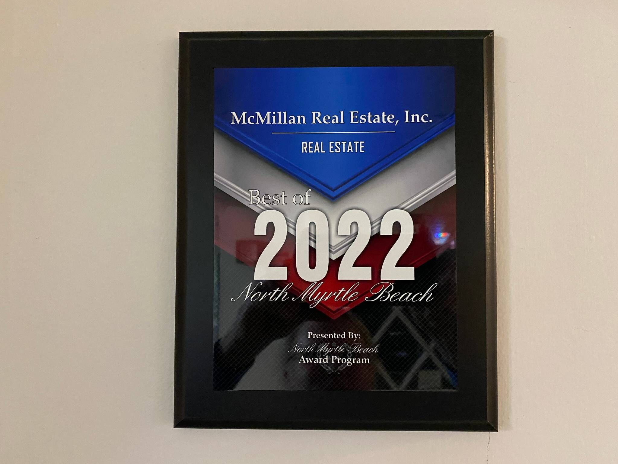 Certificado de premiação emoldurado para McMillan Real Estate, Inc., referente ao ano de 2022, concedido pelo Programa de Premiação de North Myrtle Beach.